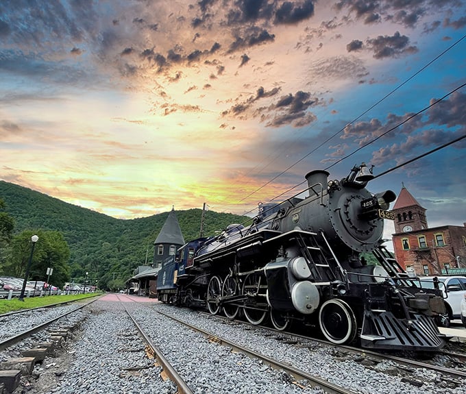This isn't just a locomotive—it's industrial poetry in black steel, standing majestically against a sunset that seems orchestrated just for this moment.