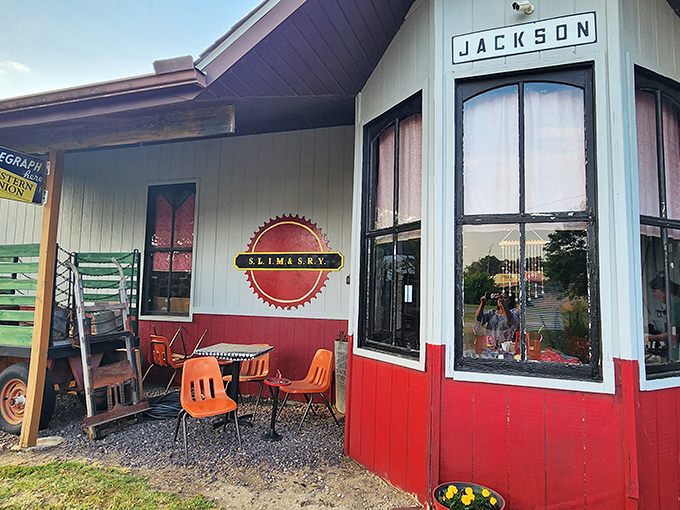 The Jackson depot stands as a cheerful sentinel of railroad history, its red and white façade a beacon to train enthusiasts and the merely curious alike.