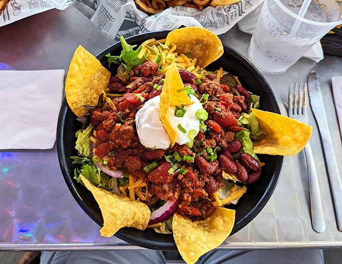 Taco salad that defies gravity and good sense—a mountain of flavor topped with a dollop of sour cream like a snowy peak on a delicious landscape.