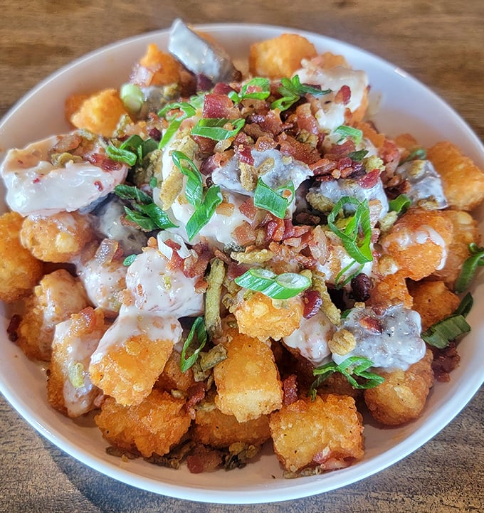 These loaded tater tots aren't just a side dish—they're the main event's scene-stealing sidekick, dressed in bacon bits and green onions.