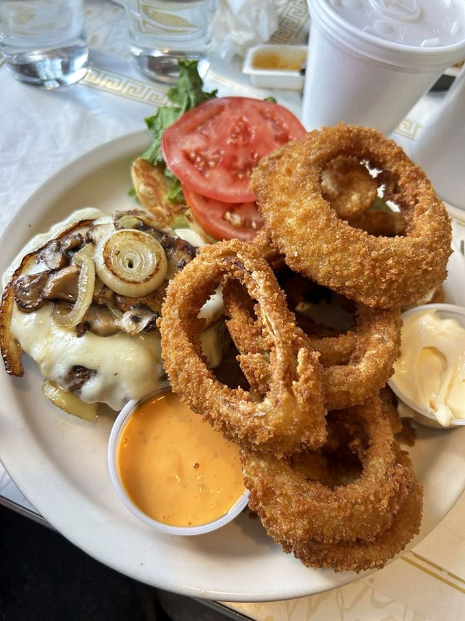 These onion rings aren't just crispy—they're the gold medal winners of the deep-fried Olympics, served alongside a burger that means business.
