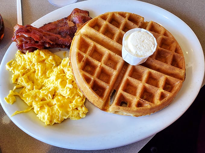 The breakfast trinity: golden waffle, fluffy scrambled eggs, and bacon that actually tastes like bacon. Morning salvation on a plate.