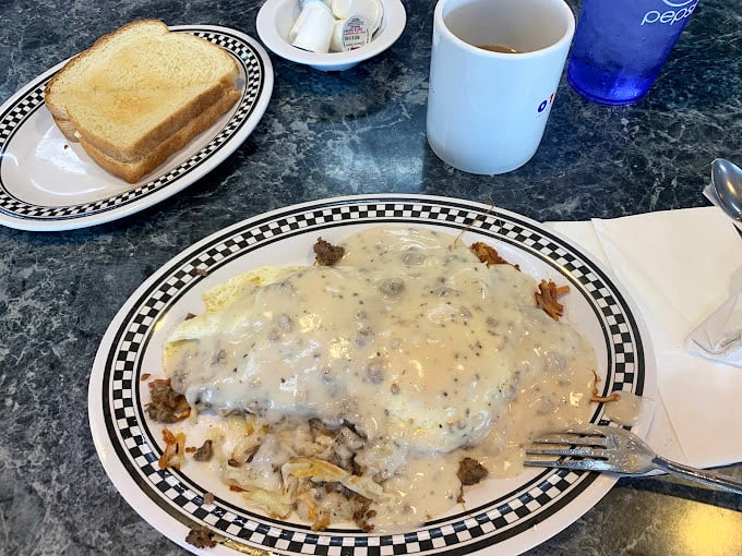 Biscuits and gravy so good they should be illegal—a creamy, peppery blanket covering potatoes that never stood a chance.