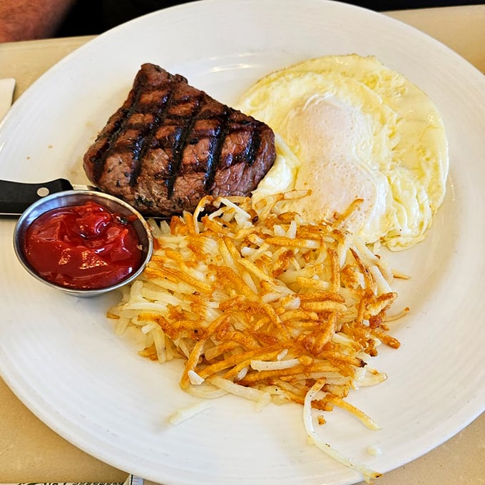 The breakfast of champions: a juicy steak, golden hash browns, and eggs sunny-side up. Morning fuel that would make Ron Swanson proud.