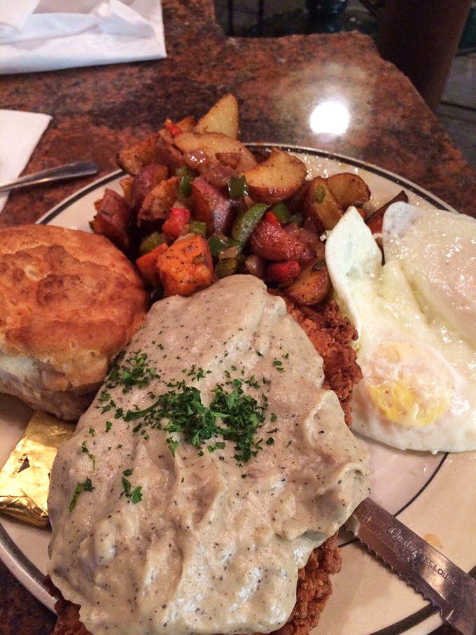 Country fried steak smothered in gravy alongside eggs and seasoned potatoes—a breakfast that says "go back to bed after this" in the most delicious way possible.