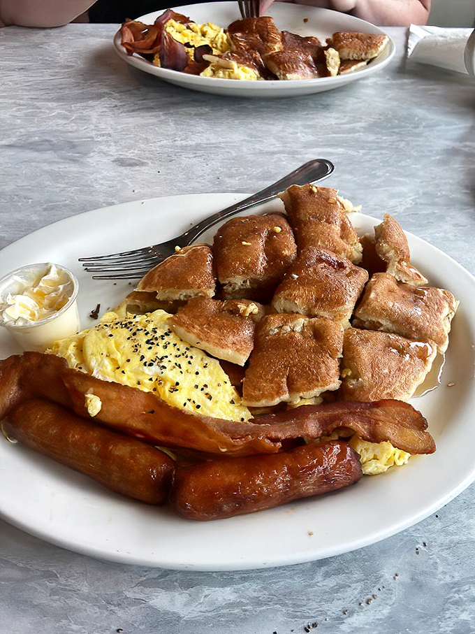 Breakfast alchemy at its finest: golden pancakes, perfectly scrambled eggs, and bacon that could make a vegetarian reconsider their life choices.