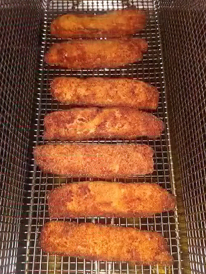 Golden treasures fresh from the fryer – these fish fillets aren't just cooked, they're transformed into crunchy-on-the-outside, tender-on-the-inside masterpieces.