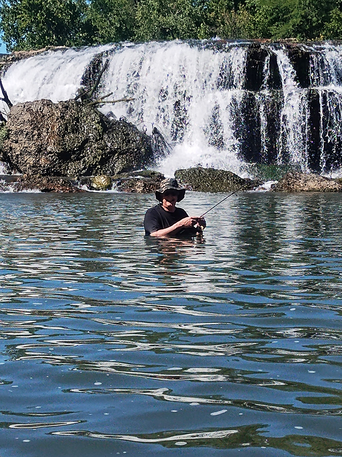 Fishing below the falls—where the angler's patience meets nature's perfect soundtrack. The fish are just a bonus.