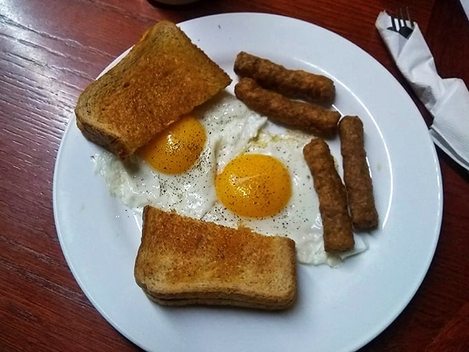 Simple perfection on a plate – golden toast, sunny-side-up eggs, and sausage links that would make even your cardiologist secretly jealous.