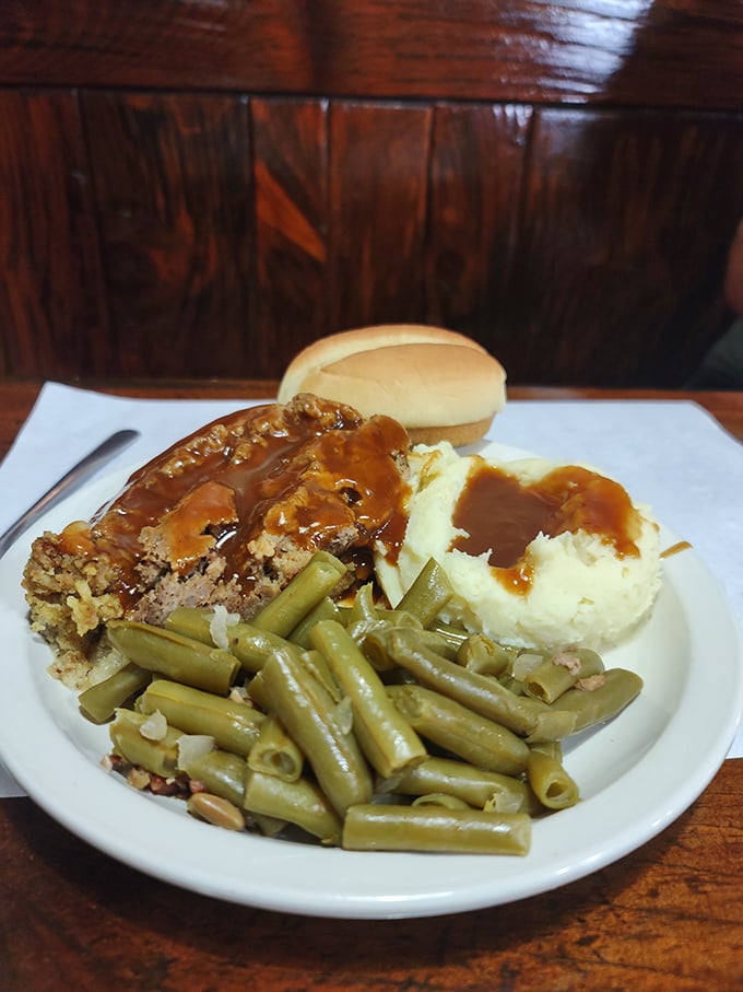 The legendary meatloaf arrives like a celebrity – flanked by green beans, mashed potatoes, and gravy that's practically auditioning for its own Food Network special.