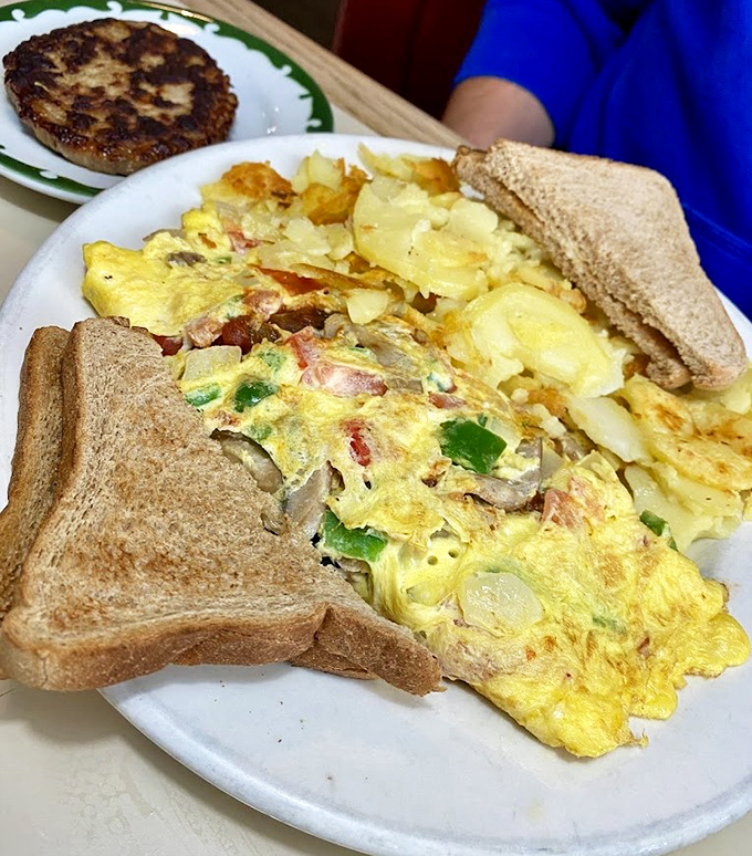 This isn't just an omelet—it's a masterclass in breakfast architecture, with perfectly distributed fillings and that golden exterior that says "good morning" better than words.
