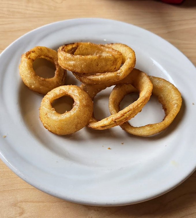 These onion rings aren't just fried to golden perfection—they're crispy, airy halos that make you wonder why vegetables ever bother showing up any other way.