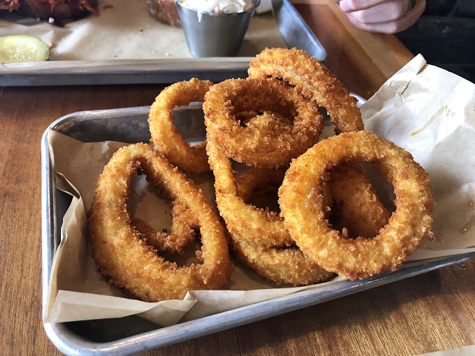These aren't just onion rings; they're golden halos of crispy perfection that make you wonder why vegetables ever bothered growing underground.