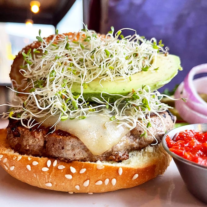 Not just any burger—this one's sporting more sprouts than a health food store and avocado slices thick enough to make a Californian weep with joy.