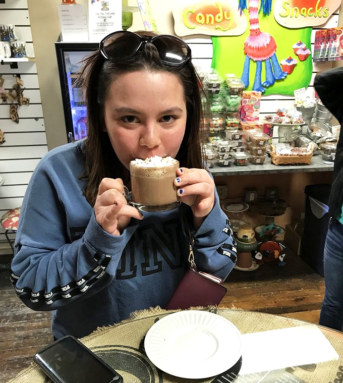A visitor enjoys a frothy beverage at the Grumpy Troll Coffee shop, where the drinks might not contain magic potions, but they'll certainly lift your spirits.