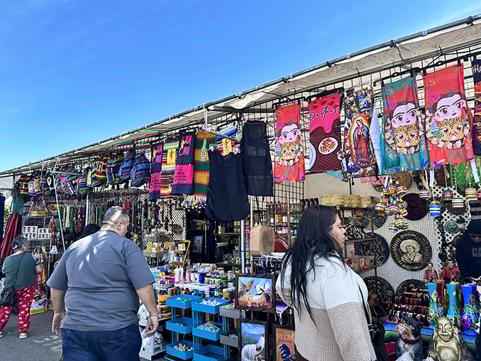 Vibrant tapestries and cultural artwork transform metal stall frames into galleries of folk art, where shoppers browse with the focus of museum patrons.
