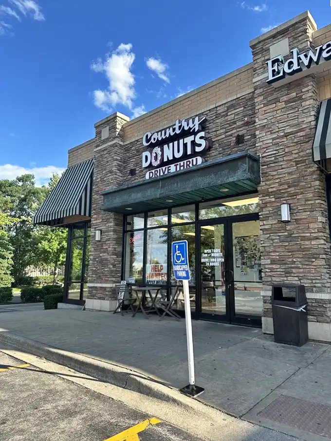 Country Donuts' rustic stone exterior feels like a cozy cabin for pastries. That "Drive Thru" sign might be the most beautiful road sign in Illinois!