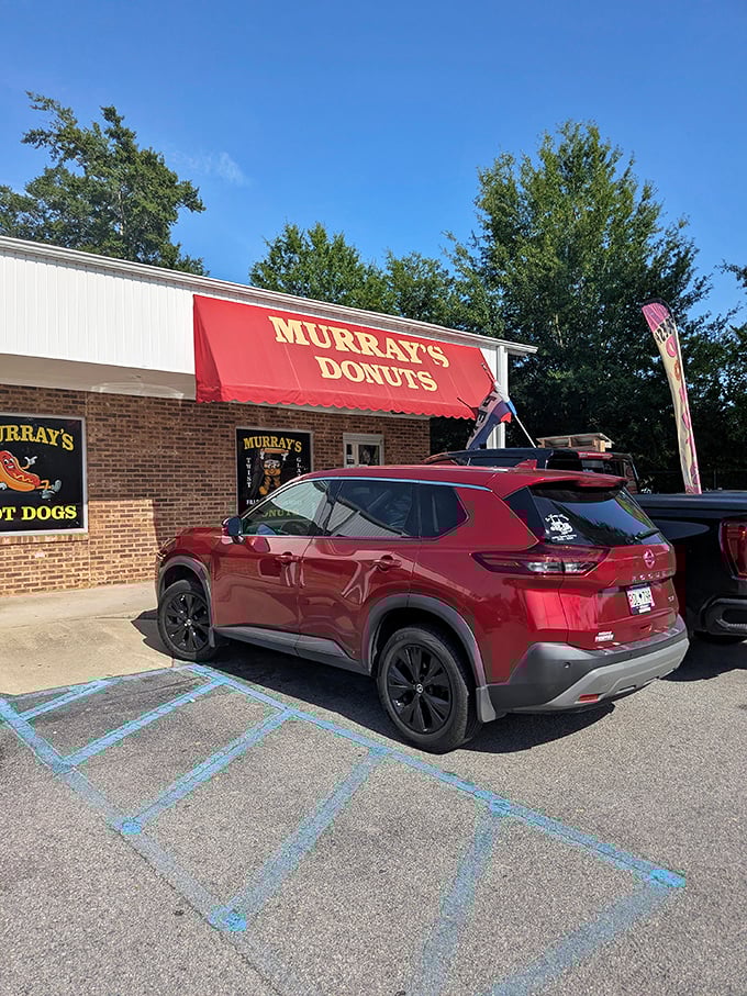 That red awning beckons like a lighthouse for anyone seeking authentic, no-nonsense donut perfection.
