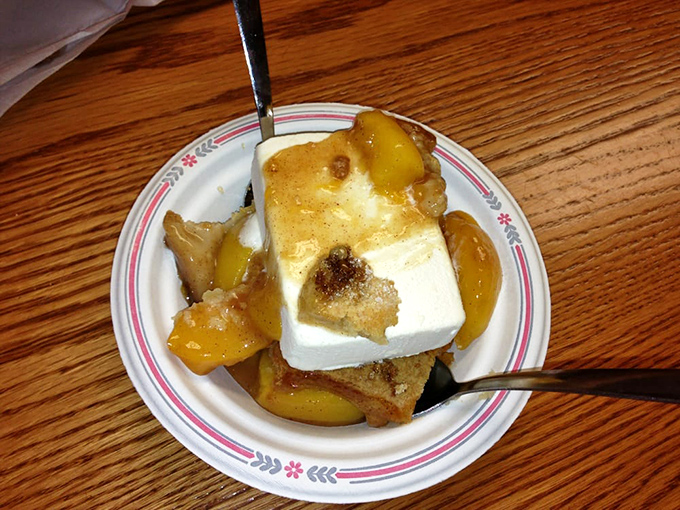Peach cobbler with ice cream melting into warm fruit and crust. The perfect sweet finale to a smoky meal.