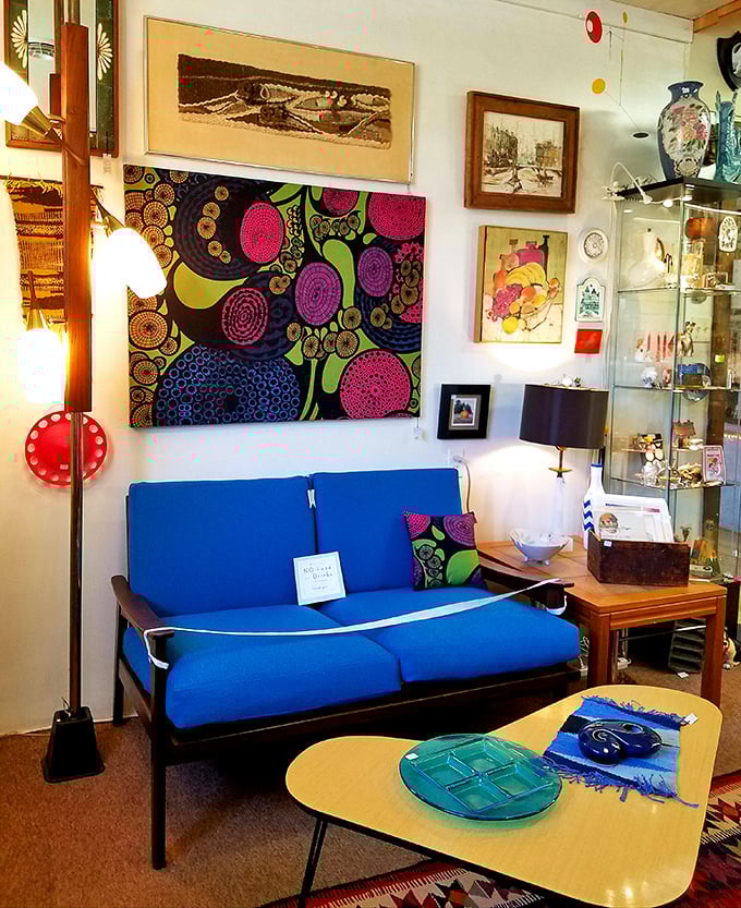 Mid-century modern heaven! This vibrant blue sofa and psychedelic artwork create the perfect living room time capsule that Don Draper would approve of.