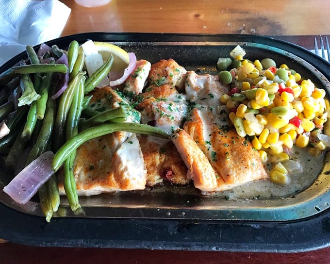 The Back Porch Mahi arrives like seafood royalty – perfectly grilled and crowned with shrimp and that legendary lemon beurre blanc sauce.