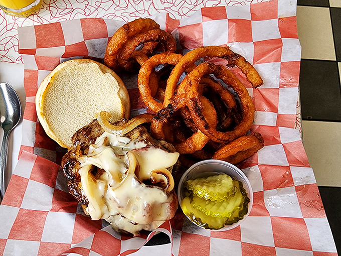 This isn't just a burger—it's a towering monument to American ingenuity, where melted cheese cascades over beef like a yellow waterfall of joy.
