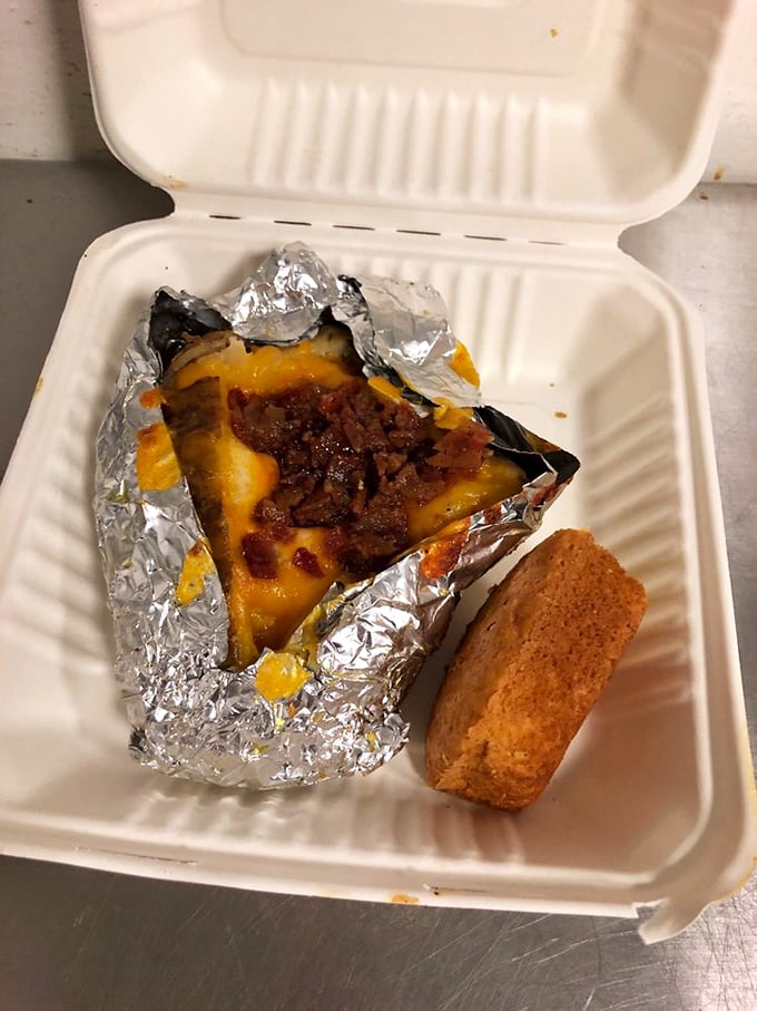 A foil-wrapped potato transformed into edible architecture—proof that sometimes the best things come wrapped like presents.