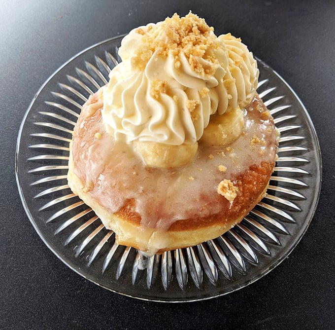 Meet the Banoffee donut—banana and toffee in perfect harmony, crowned with cream and crumble. It's like someone turned the classic British dessert into breakfast-appropriate art.