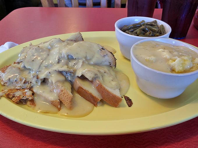 Biscuits smothered in creamy gravy alongside green beans and mashed potatoes—the Southern comfort food trifecta that hugs your soul.