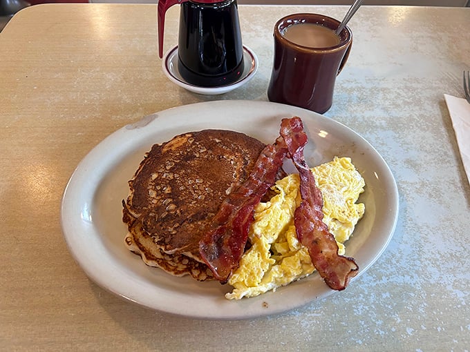 The holy trinity of breakfast: a golden pancake, scrambled eggs, and bacon that's achieved that perfect crisp-but-not-burnt state that should win culinary awards.