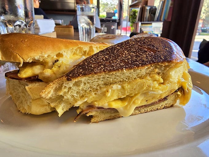 Breakfast sandwich architecture at its finest—golden bread cradling what appears to be melty egg and cheese, with plantain chips standing by for moral support.