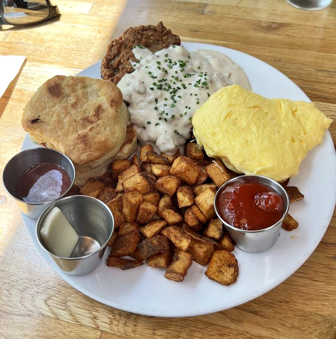 Breakfast nirvana achieved: golden home fries, a cloud-like biscuit, and gravy that could make a vegetarian temporarily question their life choices.