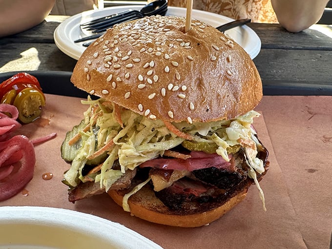 The sandwich that launched a thousand road trips. Layers of smoked meat and slaw between golden brioche—worth every mile of the journey.