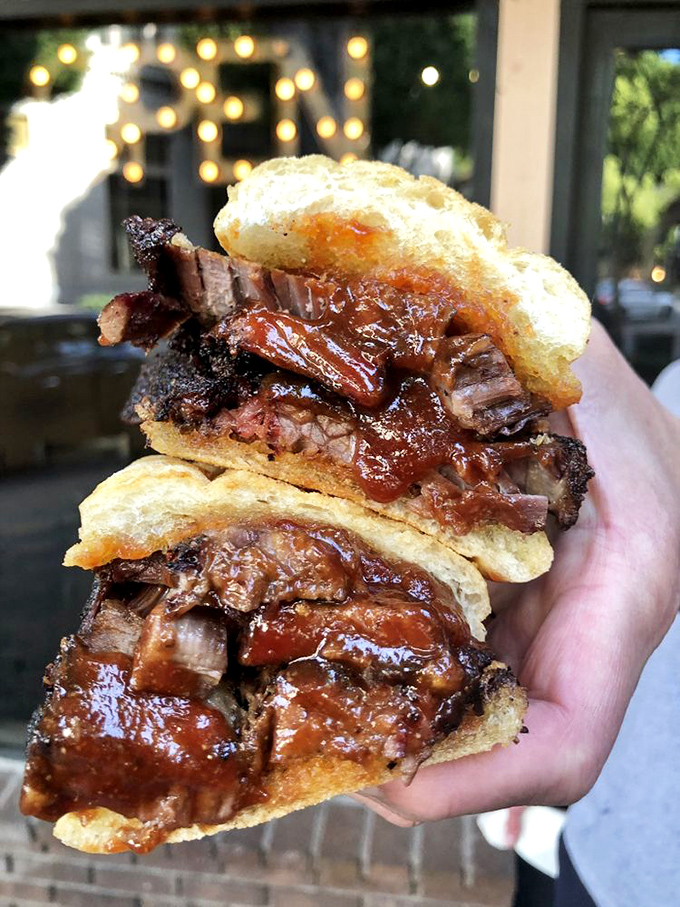 A brisket sandwich that requires both hands and your undivided attention. This isn't a meal – it's a commitment.