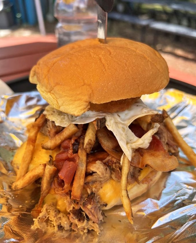 Not just a burger—it's an architectural marvel. Layers of pulled pork, fries, and cheese create a tower of power that requires both hands and zero shame.