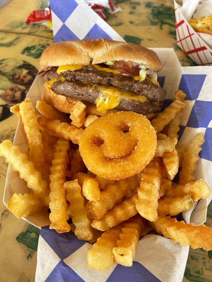 Behold the Snow Cap burger in its natural habitat—surrounded by crispy fries and that signature smiley-faced onion ring that's practically winking at you.