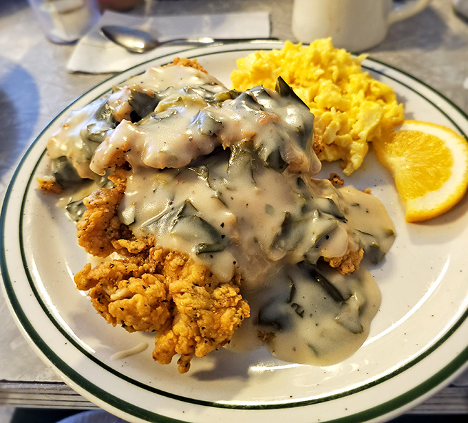 Chicken and gravy cascading over golden scrambled eggs—a breakfast that doesn't just start your day, it makes your whole week.