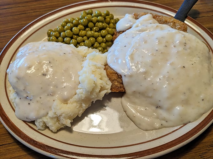 Behold the country-fried steak – a Midwestern masterpiece swimming in gravy that your cardiologist warned you about but your soul desperately needs.