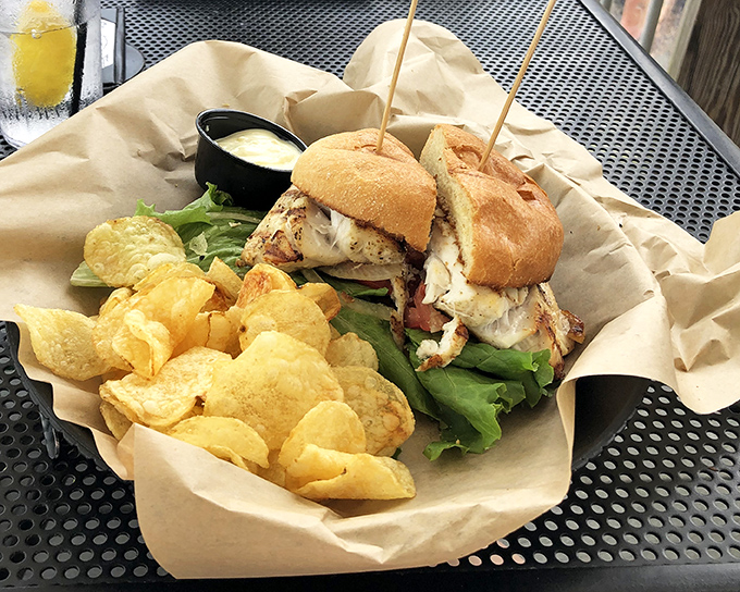 Not just a sandwich but an architectural marvel—layers of fresh fish, crisp lettuce, and soft bun creating the Taj Mahal of seafood handholds.