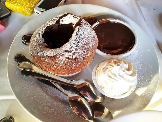 Not just dessert, but a chocolate revelation—this soufflé with its powdered sugar crown demands a moment of respectful silence before diving in.