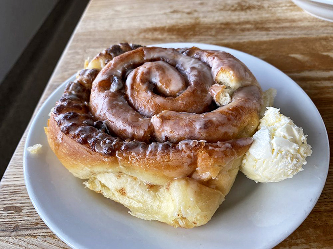 This cinnamon roll isn't just breakfast – it's an event, a commitment, a relationship that demands both a fork and napkin strategy.