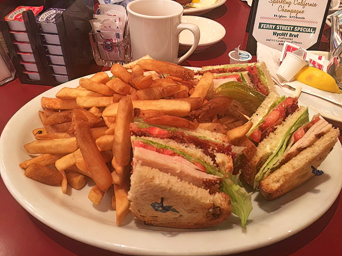 This club sandwich isn't playing around—it's a skyscraper of flavor that requires both hands and possibly an engineering degree.