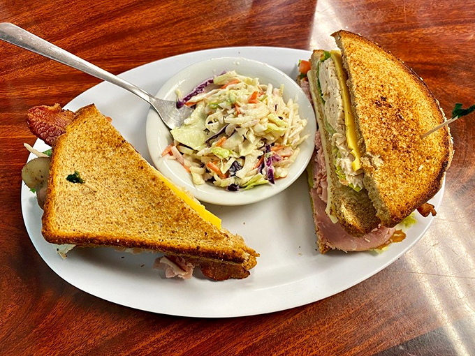 This isn't just a sandwich; it's architecture. Golden-toasted bread, perfectly stacked fillings, and that coleslaw side acting as the perfect counterpoint. 