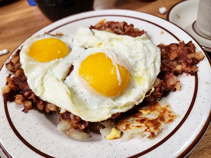 Breakfast perfection: sunny-side up eggs crowning a throne of crispy corned beef hash—the morning royalty that rules the day.
