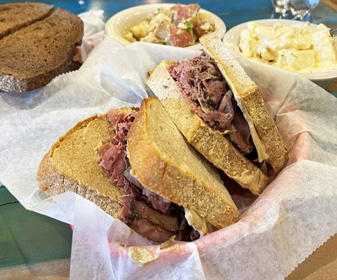 Layers of thinly-sliced corned beef nestled between dark pumpernickel—a flavor skyscraper that laughs at your attempt to open wide enough.