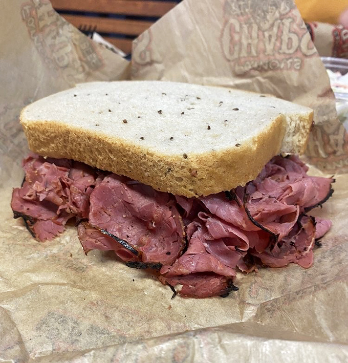 Corned beef so tender it practically surrenders to gravity, stacked between slices of rye bread. This isn't a sandwich – it's an engineering marvel.