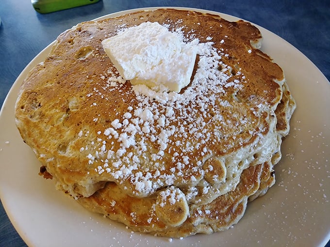 The legendary cornmeal buttermilk pancakes arrive dusted with powdered sugar like fresh snow on the Pennsylvania hills—a golden disk of breakfast perfection.