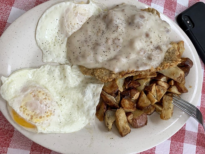 Country fried steak smothered in gravy with eggs sunny-side up – the breakfast trifecta that makes getting out of bed worthwhile.