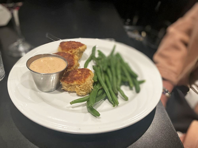 Golden-brown crab cakes with a side of fresh green beans—proof that seafood can find its perfect expression even in the heartland.