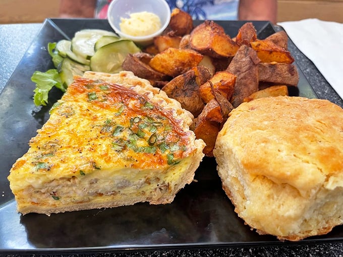 The holy trinity of breakfast bliss: a golden-topped quiche, a biscuit that could make your grandmother jealous, and home fries worth fighting over.